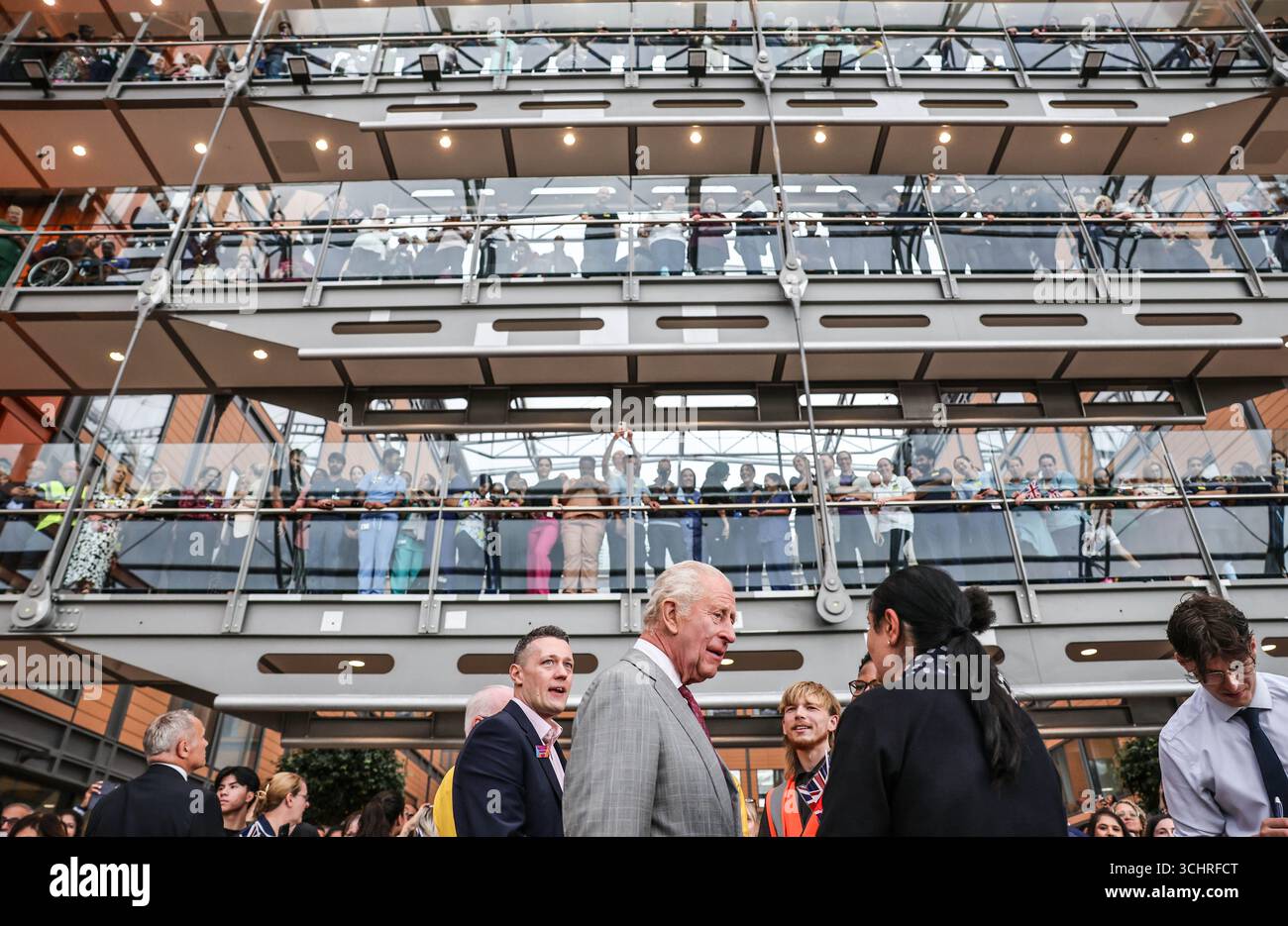 Staff, visitors and patients line the walkways to see King Charles III ...