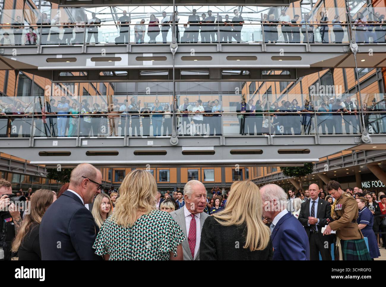 Staff, visitors and patients line the walkways to see King Charles III ...