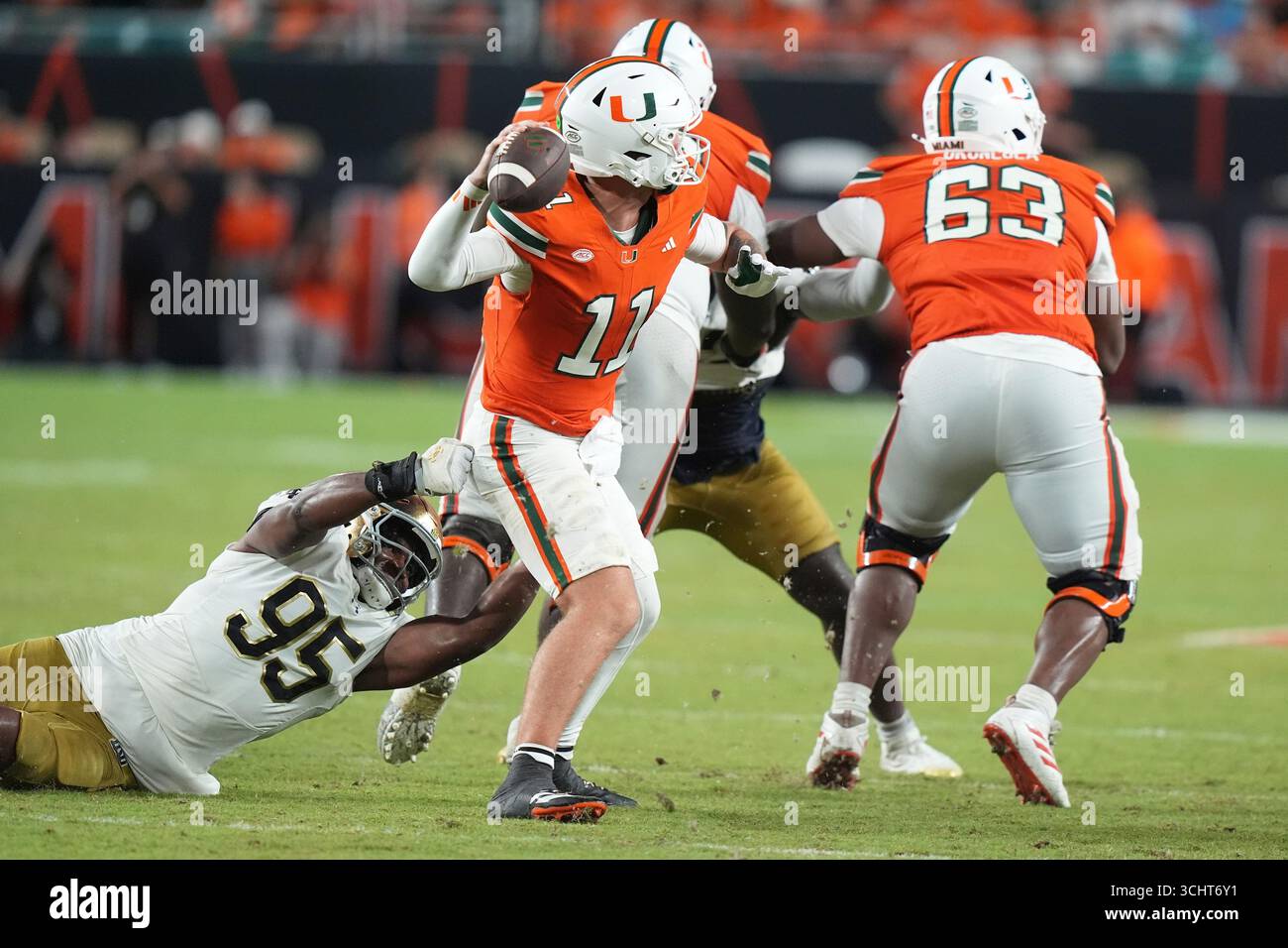 Notre Dame defensive lineman Bryce Young (95) defends Miami quarterback ...