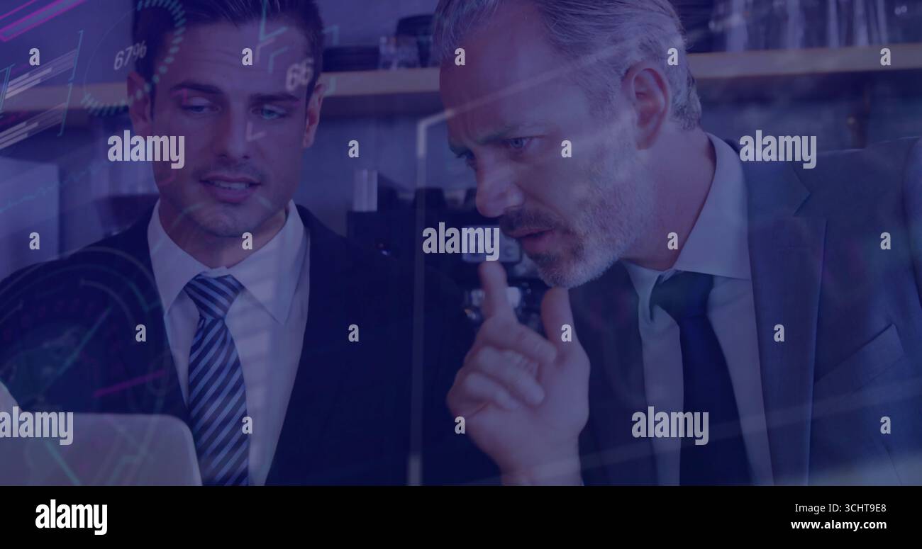 Leaning business professionals reviewing graphical charts on laptop at ...