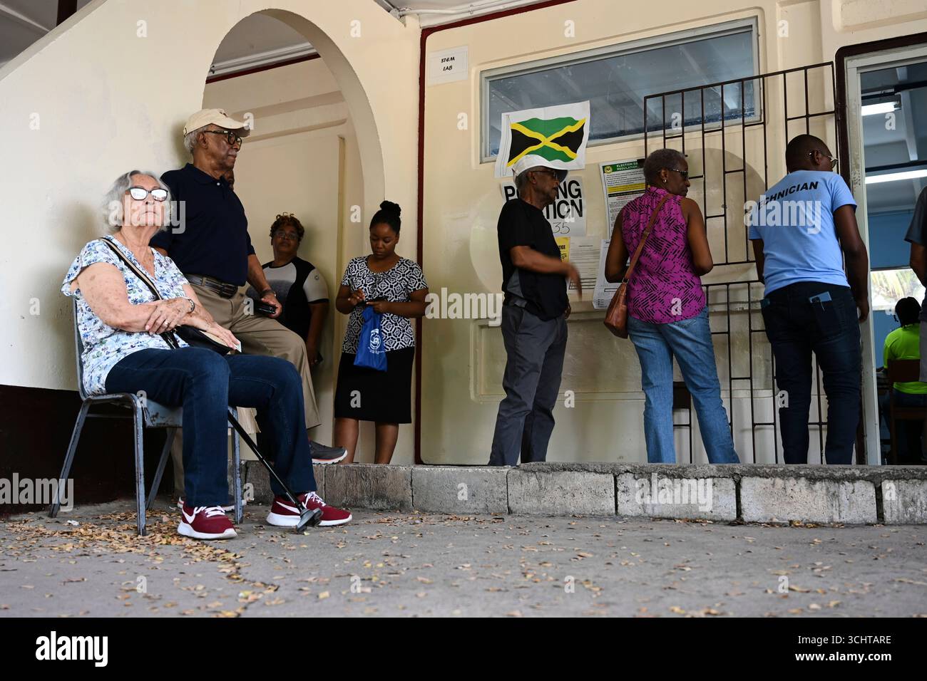 People stand in line to vote at a polling station during general ...