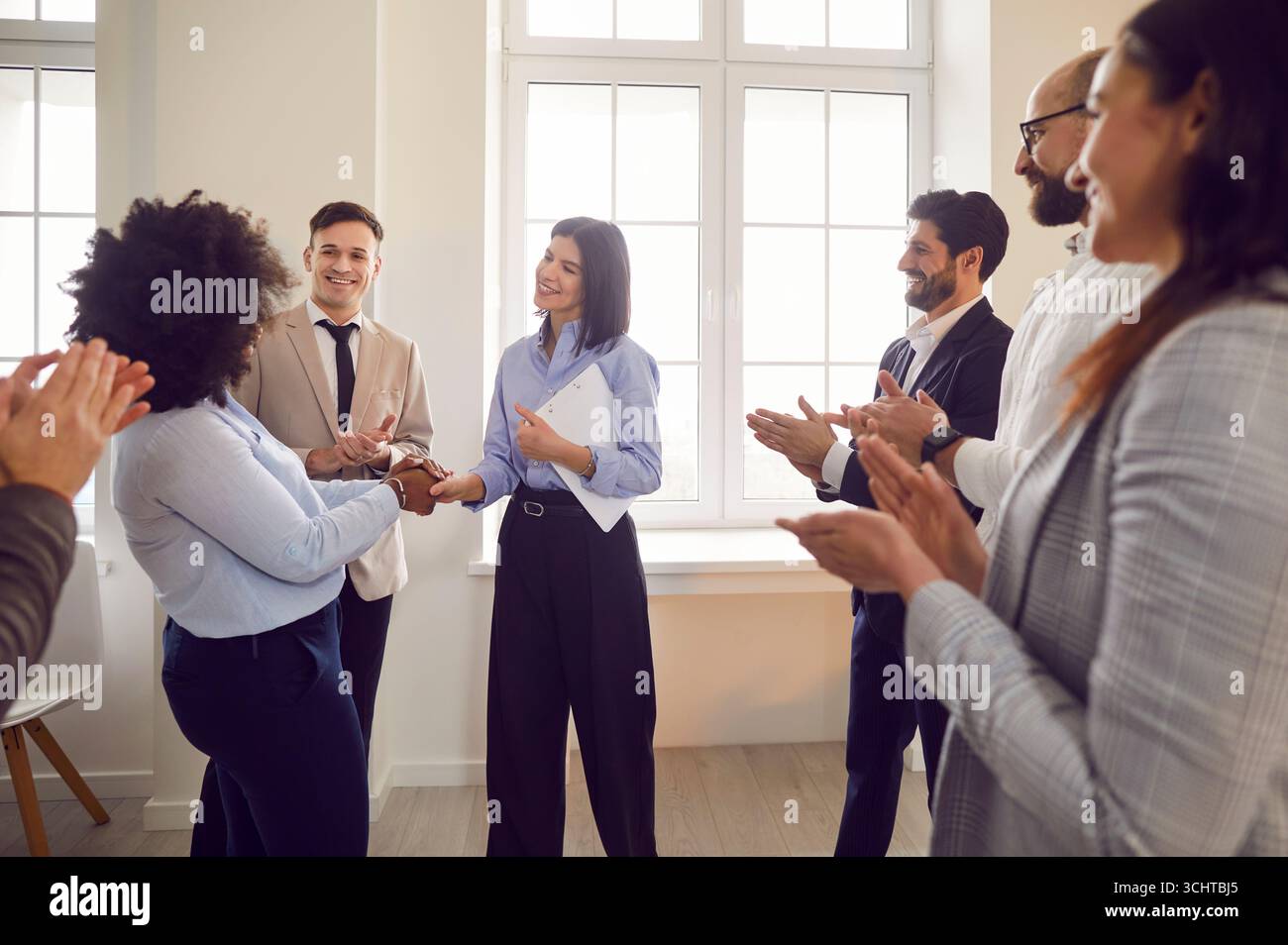 Happy smiling employees warmly welcoming new worker on workplace ...