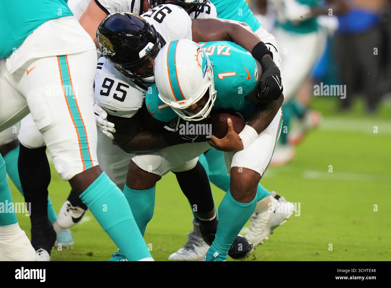 Miami Dolphins quarterback Tua Tagovailoa, left, is sacked by ...