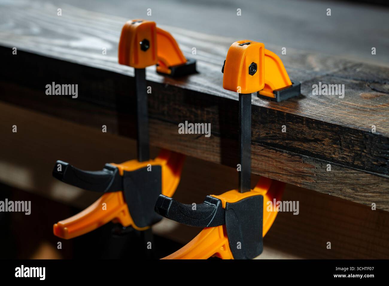 Carpenter two clamps are fixed to boards, close up. Carpentry tools in ...