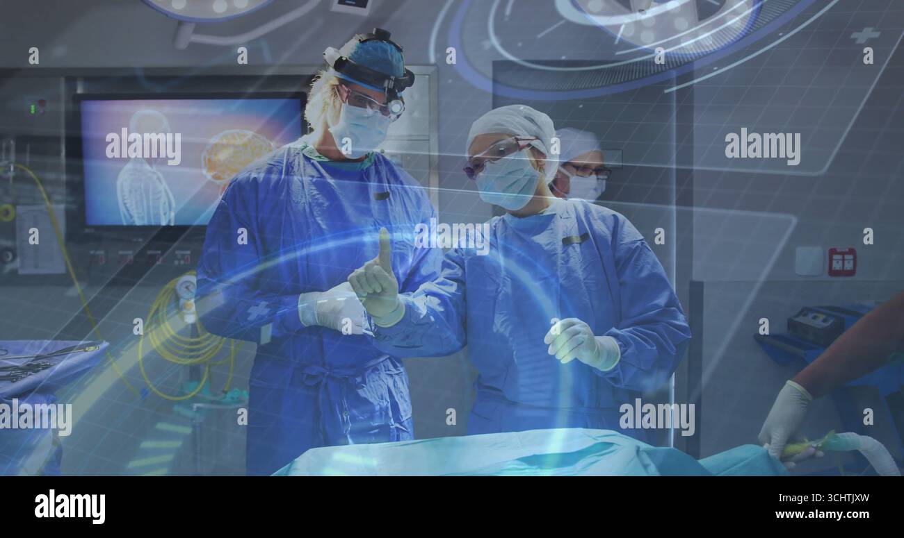 Two surgeons in scrubs gesturing to holographic interface above table ...