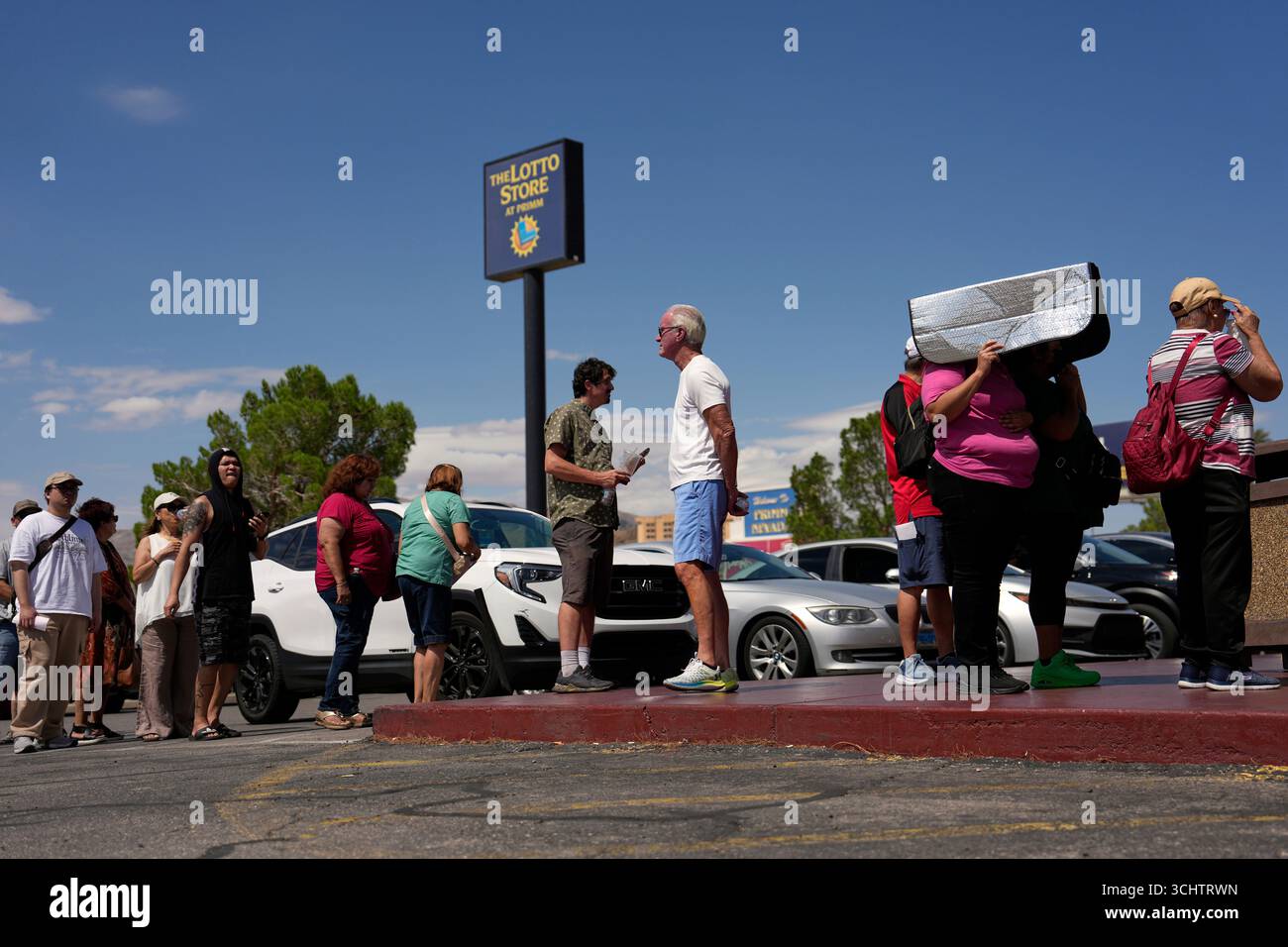 People wait in line to buy lottery tickets at the Lotto Store just ...