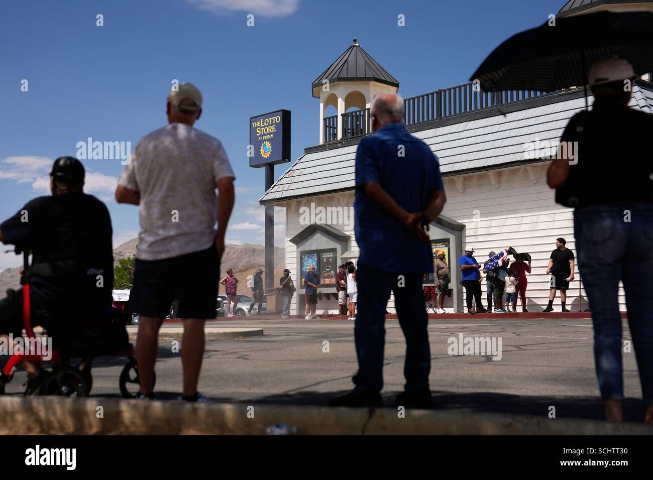 People wait in line to buy lottery tickets at the Lotto Store just ...