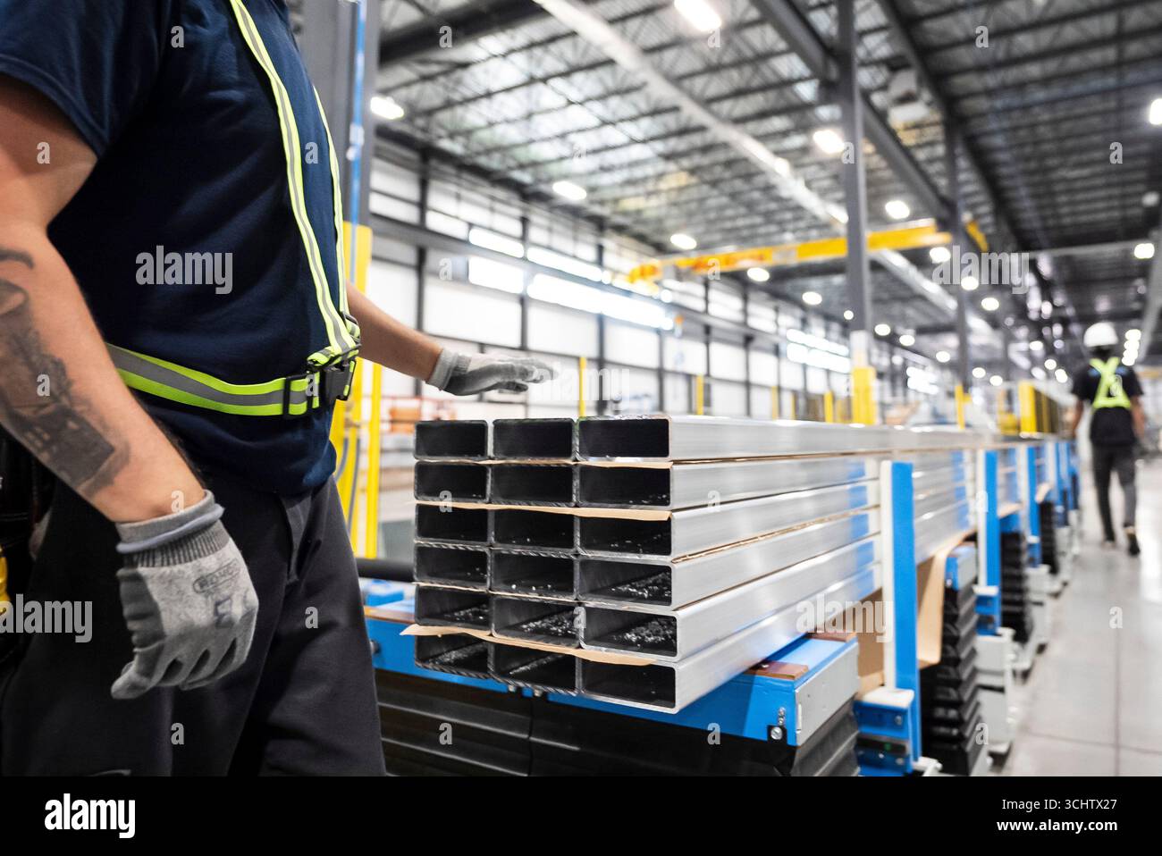 Workers prepare extruded aluminum product for packaging at Magna ...