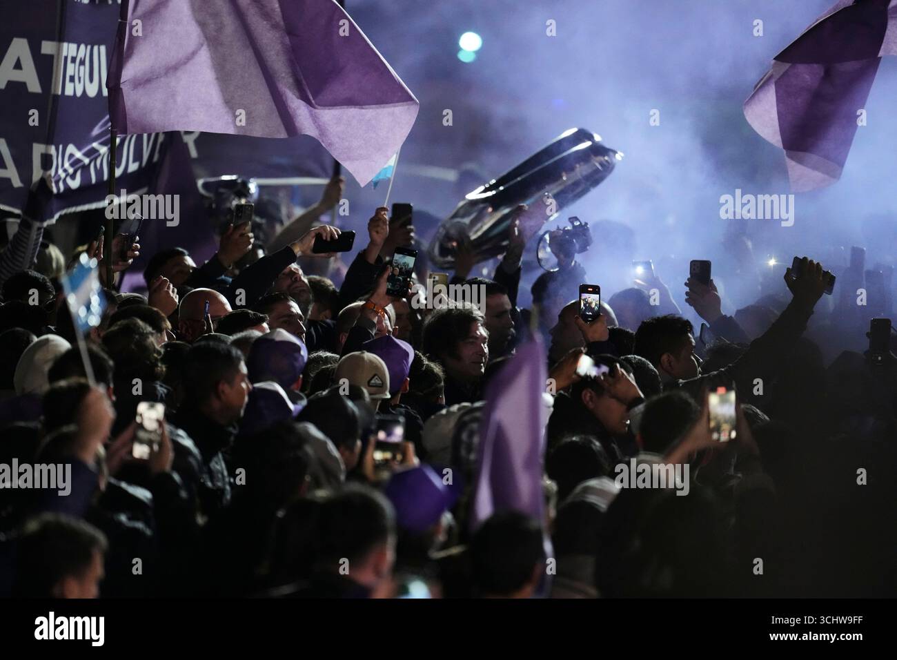 President Javier Milei stands among supporters during a campaign rally ...