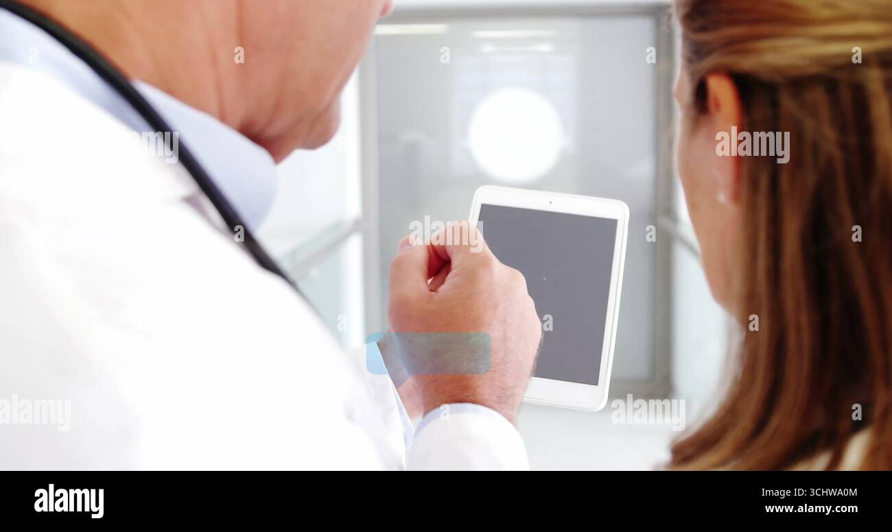 Guiding doctor wearing coat and stethoscope showing senior patient ...