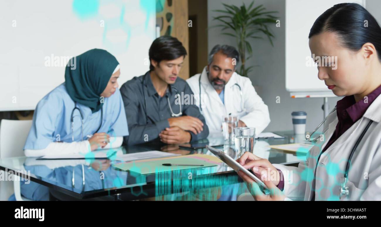 Doctor in lab coat using tablet in hospital conference room, with ...