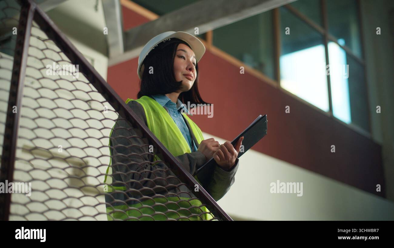 Asian Japanese inspector woman builder in hard hat checking building ...