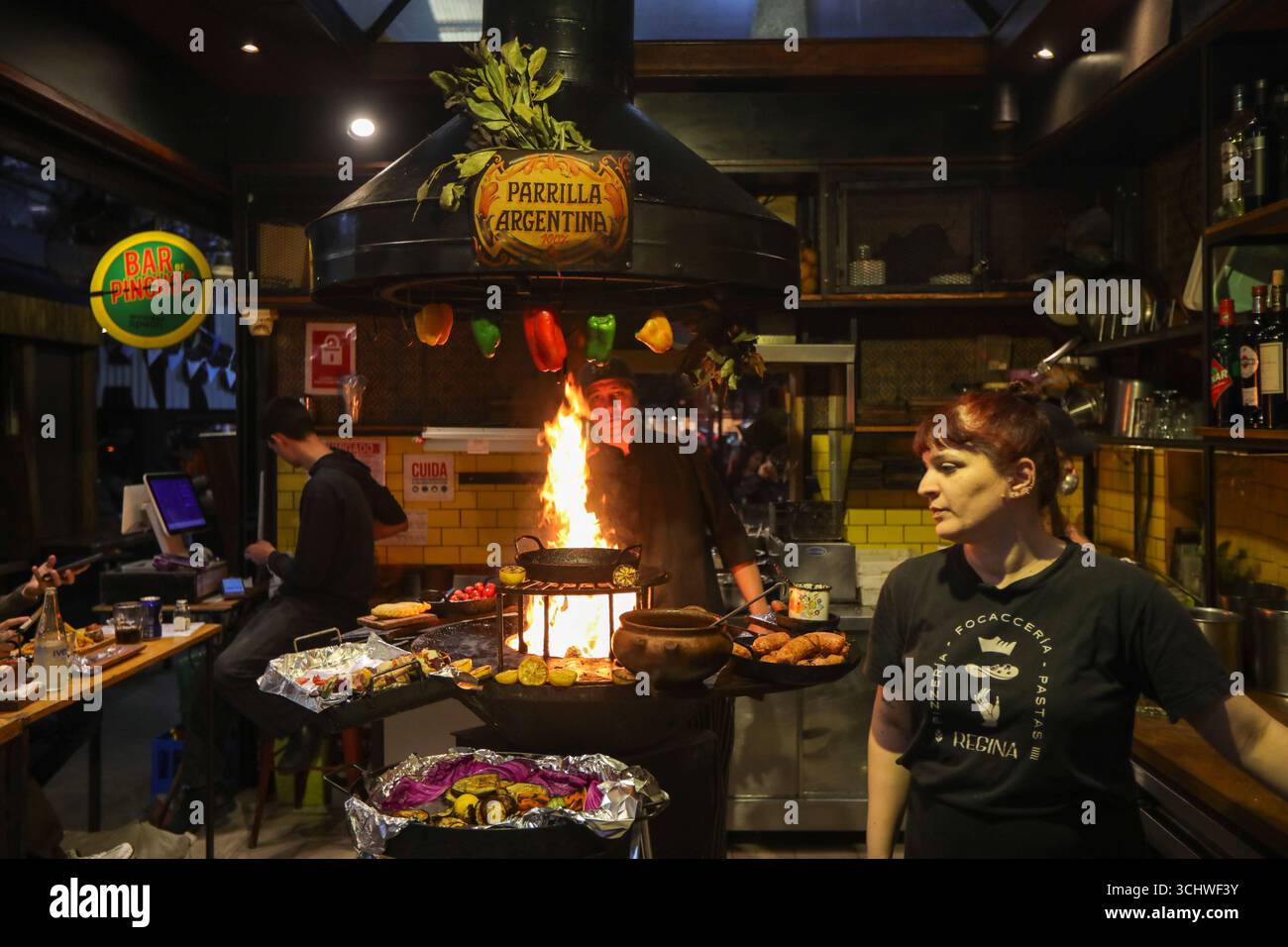 Tourism in Argentina A chef tends the fire at a Parrilla restaurant ...