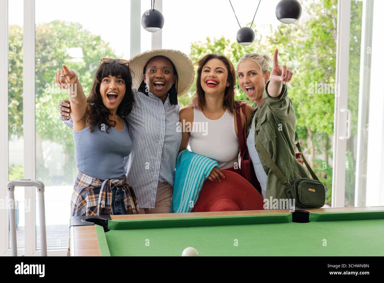 Group of diverse women enjoying time together, smiling and pointing ...