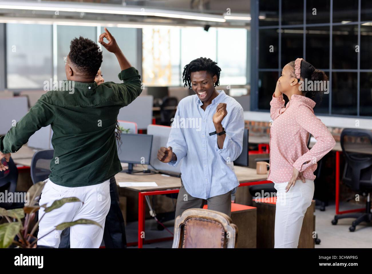 In office, colleagues celebrating successful project, dancing joyfully ...