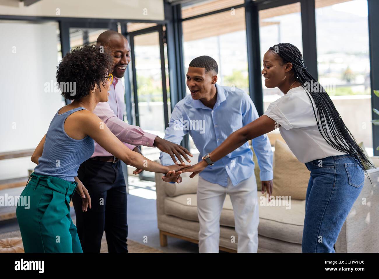 In office, diverse colleagues joining hands celebrating teamwork and ...
