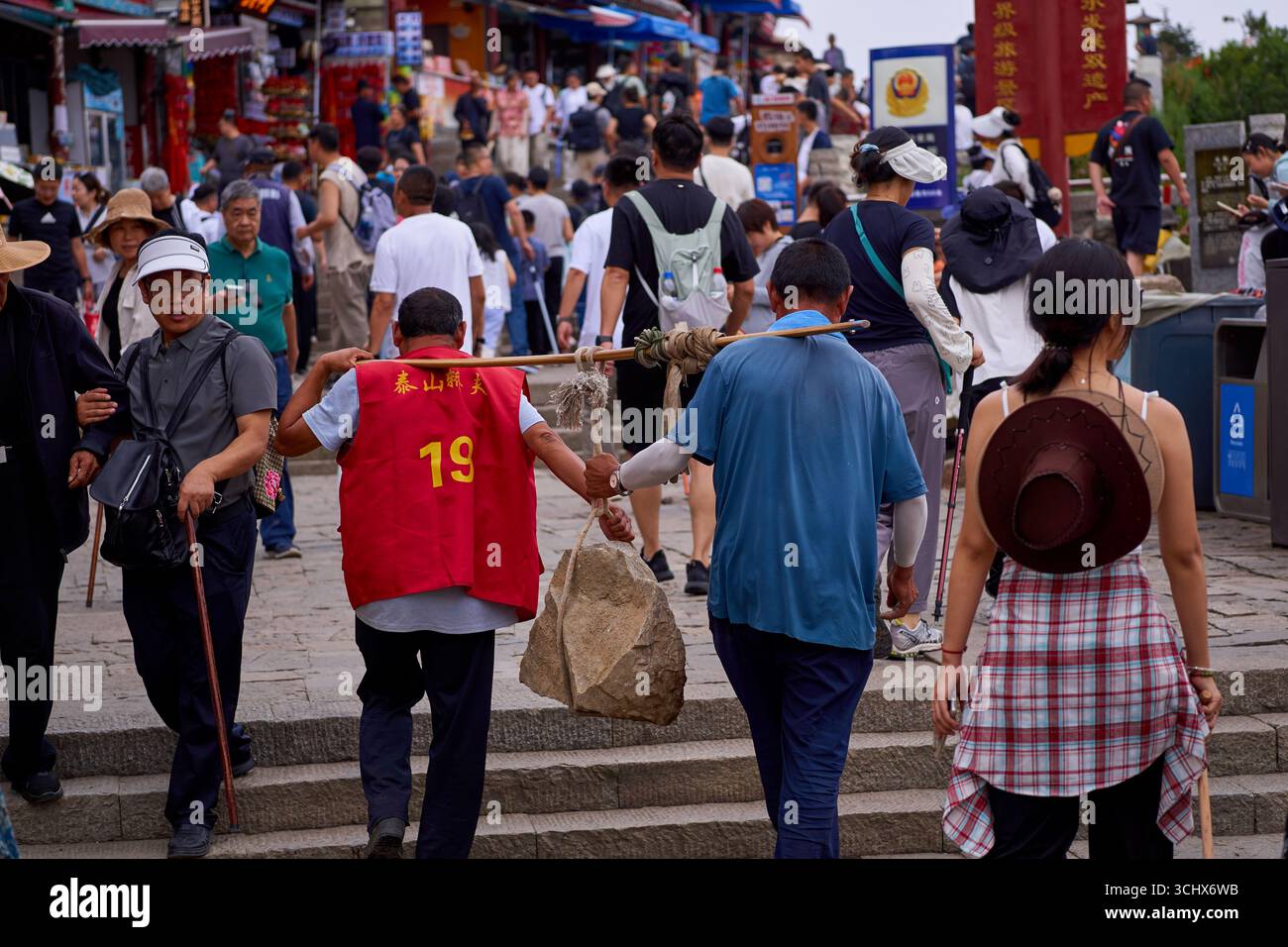 Porter carrying heavy load on the summit of Taishan or Mount Tai, the ...