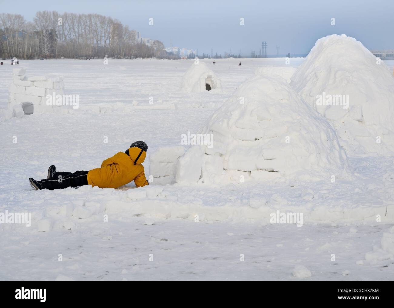 The boy lay down next to the igloo, a national shelter from the cold of ...