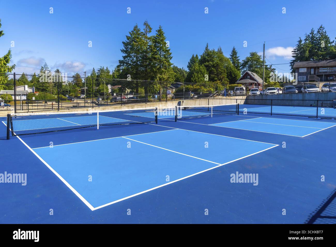 Four vibrant blue pickleball courts, featuring nets and white lines ...
