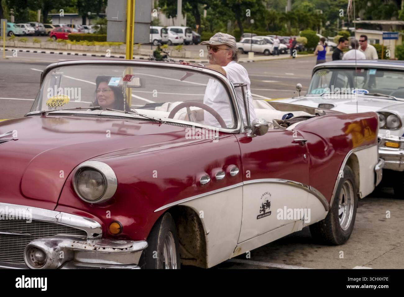 Tourists in a red convertible, red vintage convertible in the street ...