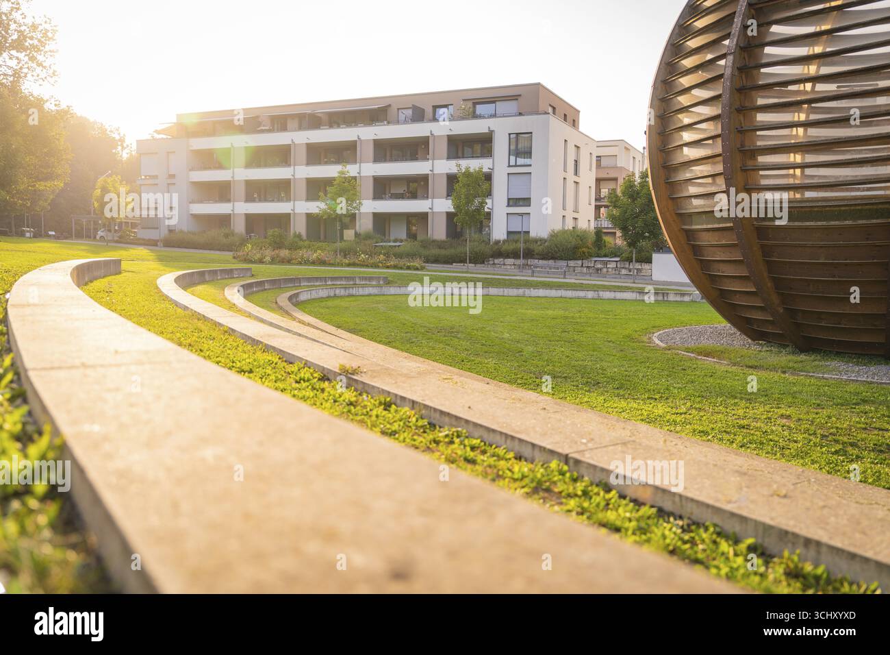 Wooden sphere-shaped structure next to modern residential complex in ...