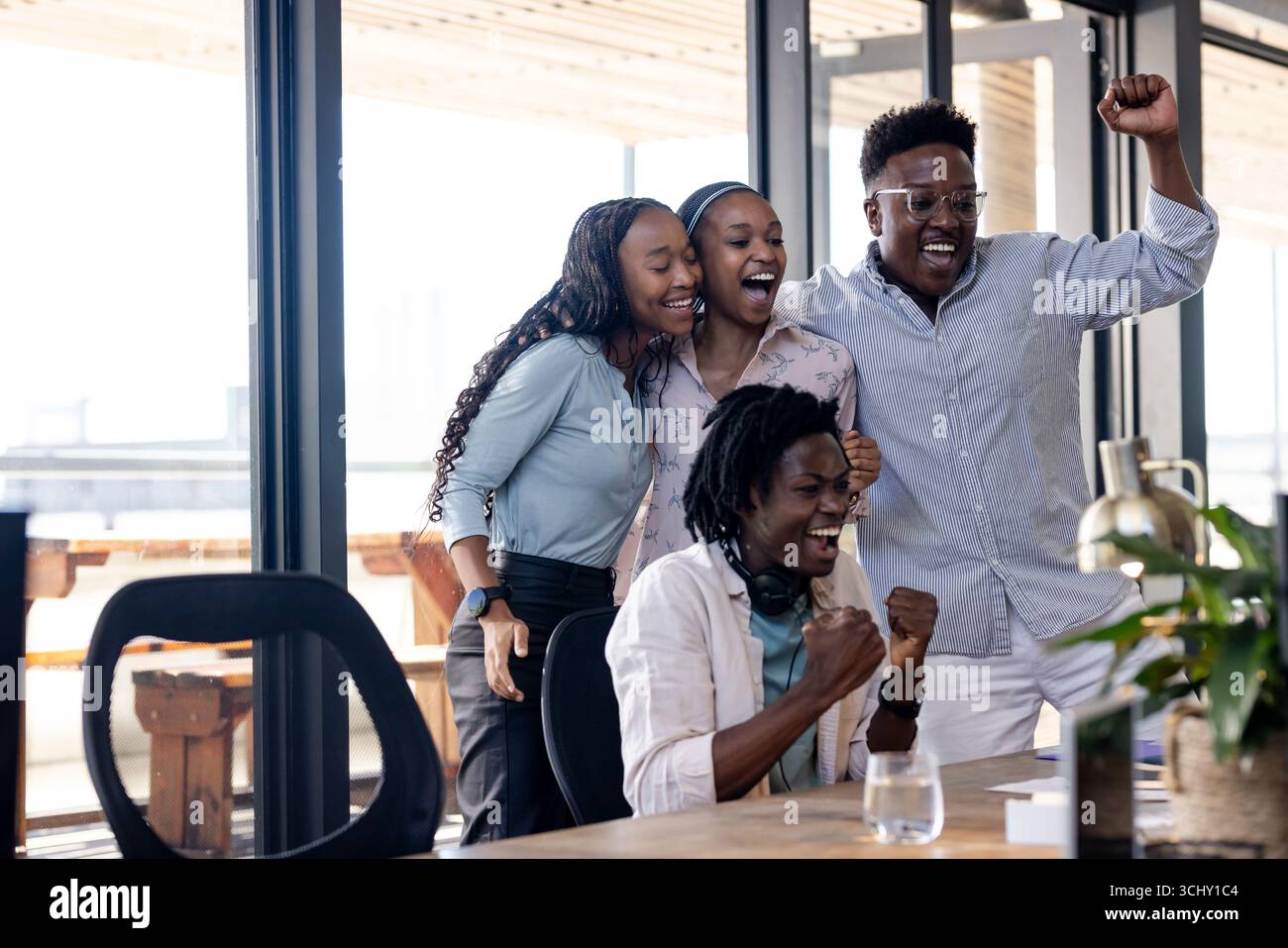Diverse team celebrating success in modern office, showing excitement ...