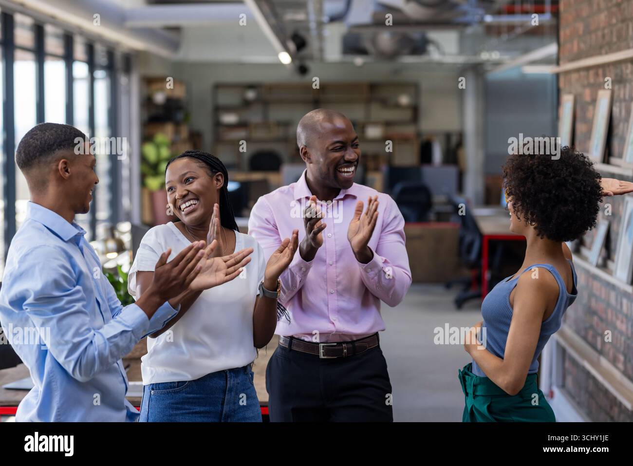 Colleagues in office clapping and celebrating success with joyful ...