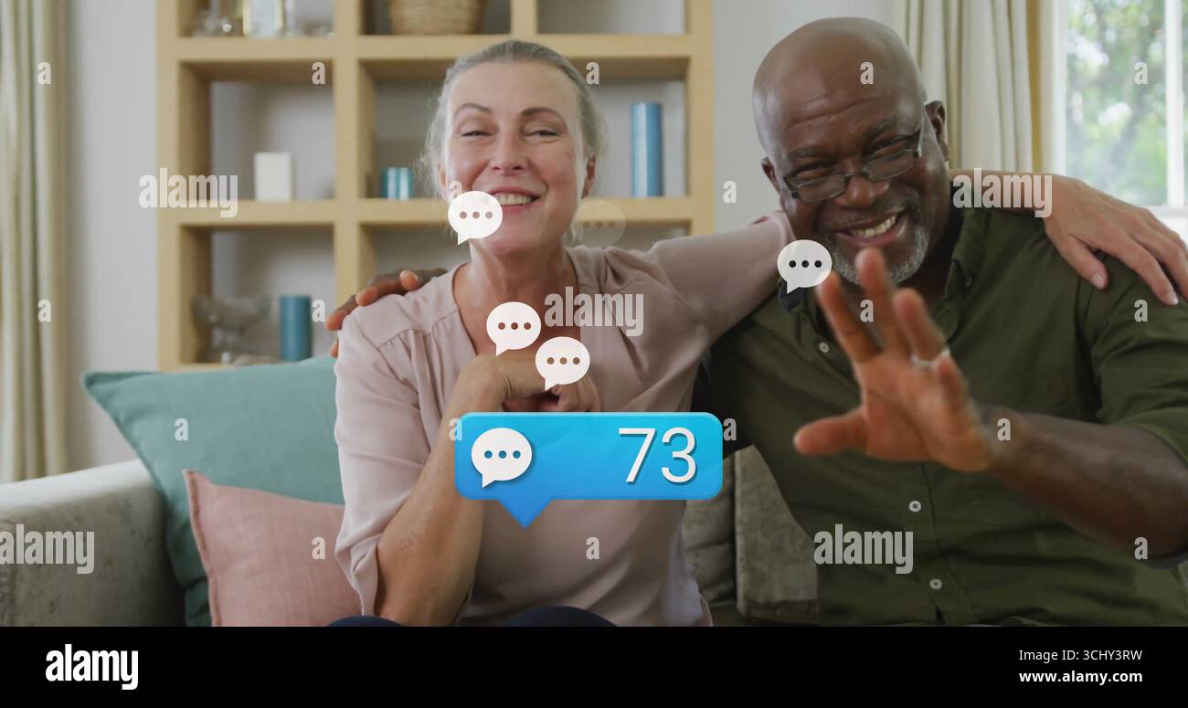 Smiling senior Black man and woman in pink blouse sitting on sofa ...