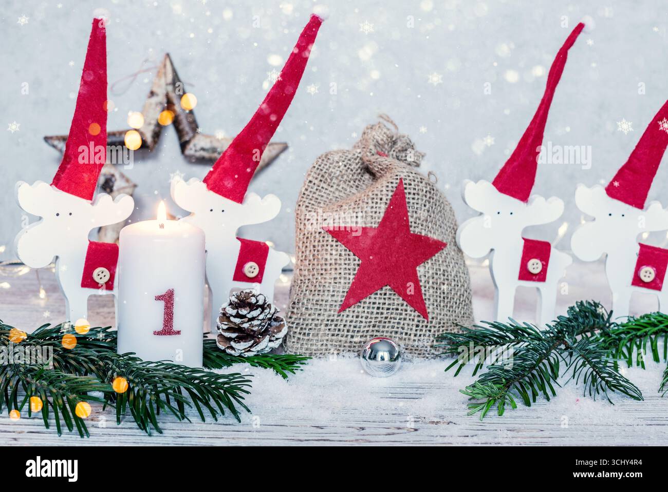 one burning candle in front of cute little Christmas elks, first Advent ...