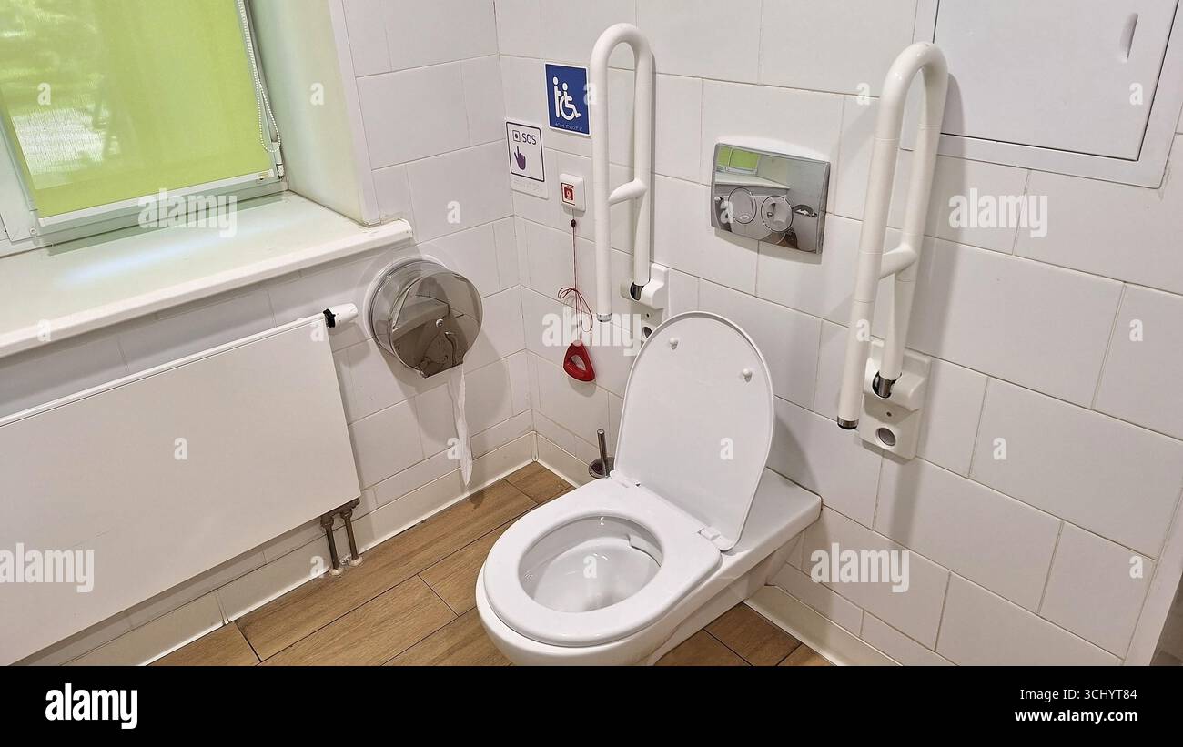 Accessible public restroom with safety rails and emergency cord Stock ...