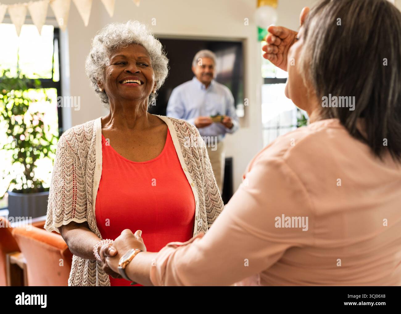 Senior diverse senior women dancing joyfully at home during celebration ...