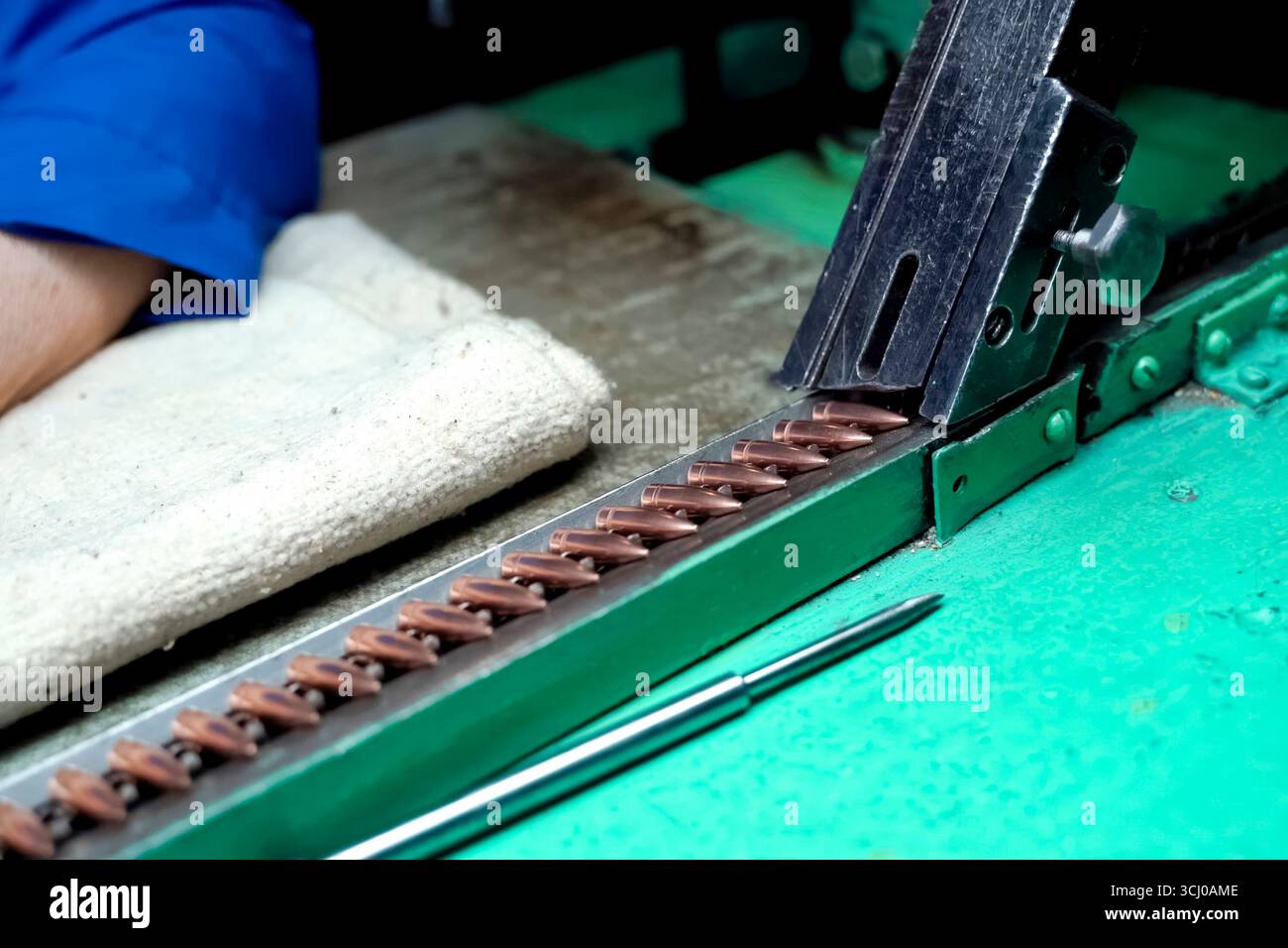 A conveyor line of cartridge cases and bullets is quality controlled by ...
