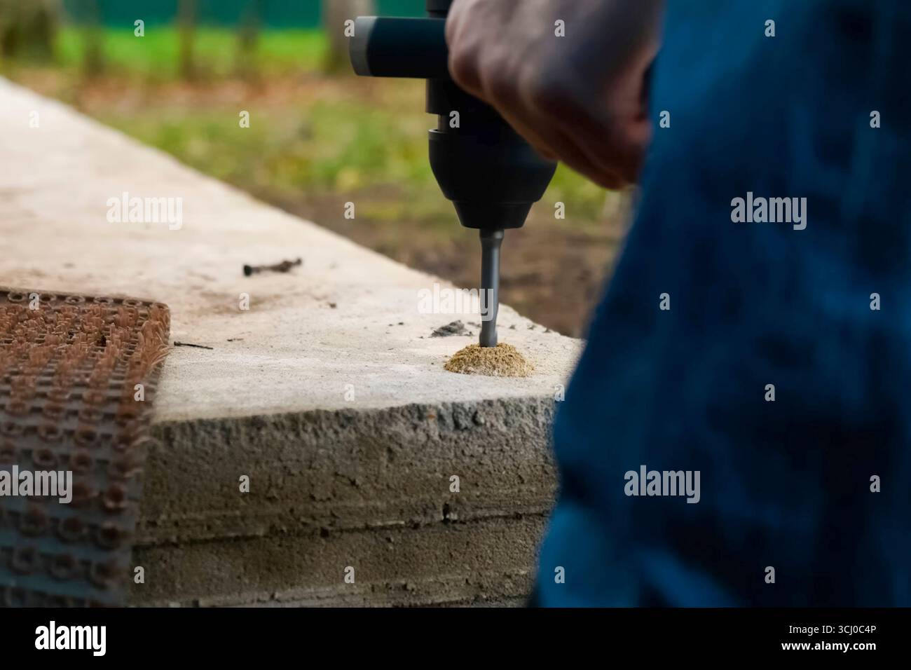 Drilling a hole in a concrete slab with a perforator Stock Photo - Alamy