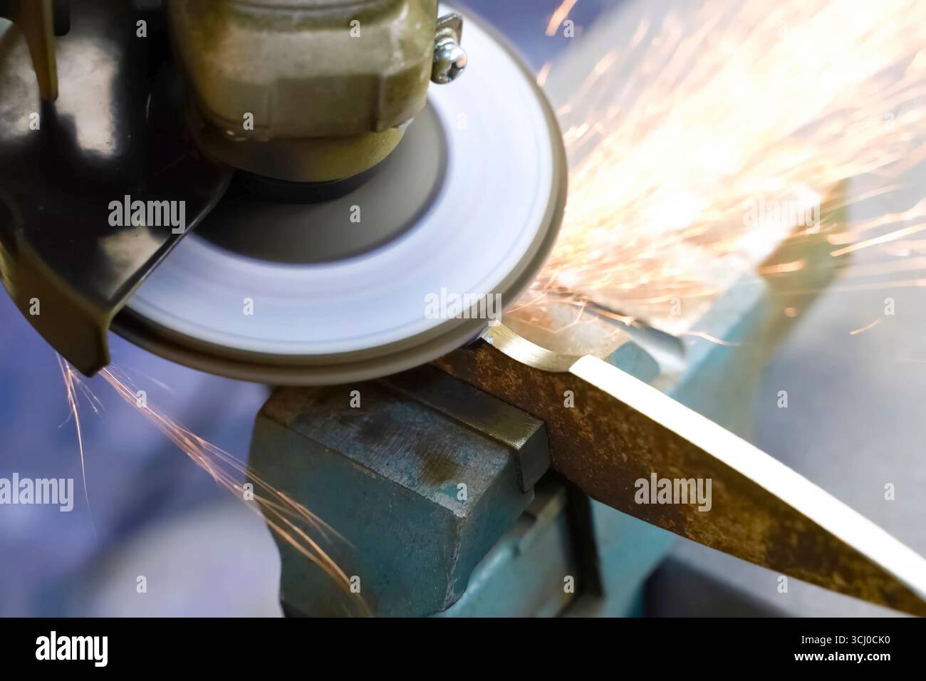 Grinding a throwing knife in a vise using an angle grinder Stock Photo ...