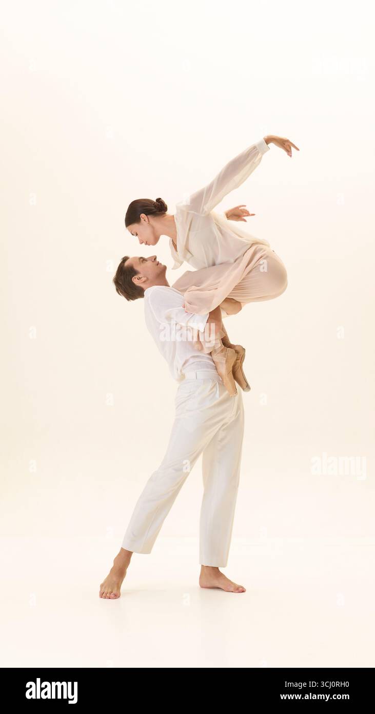 Ballet couple lift in white costumes with graceful movement, harmonious ...