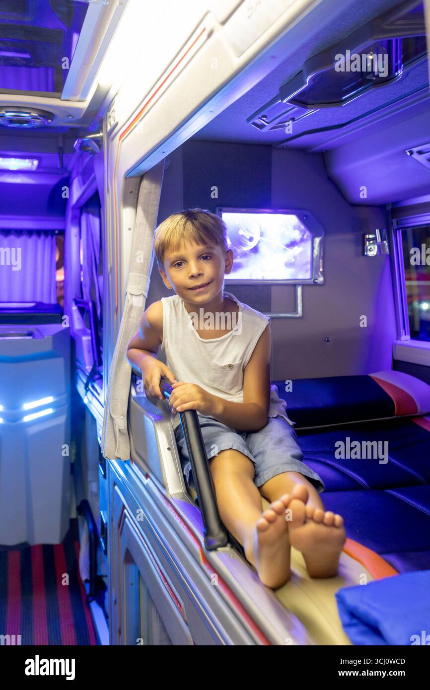 Child, boy, traveling in a sleeper bus in Vietnam, bed seat in the bus ...