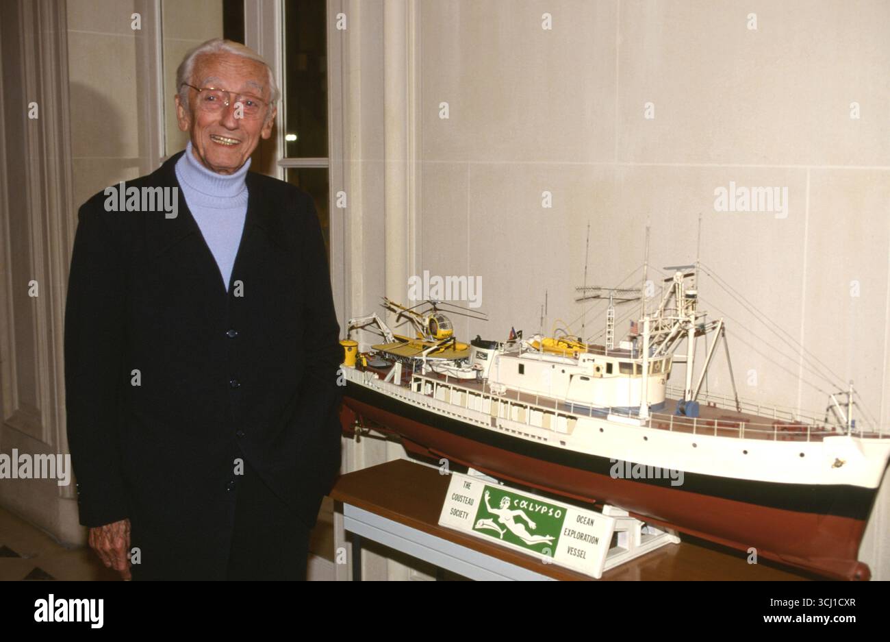 Jacques-Yves Cousteau in front of a model of the ship Calypso at the ...