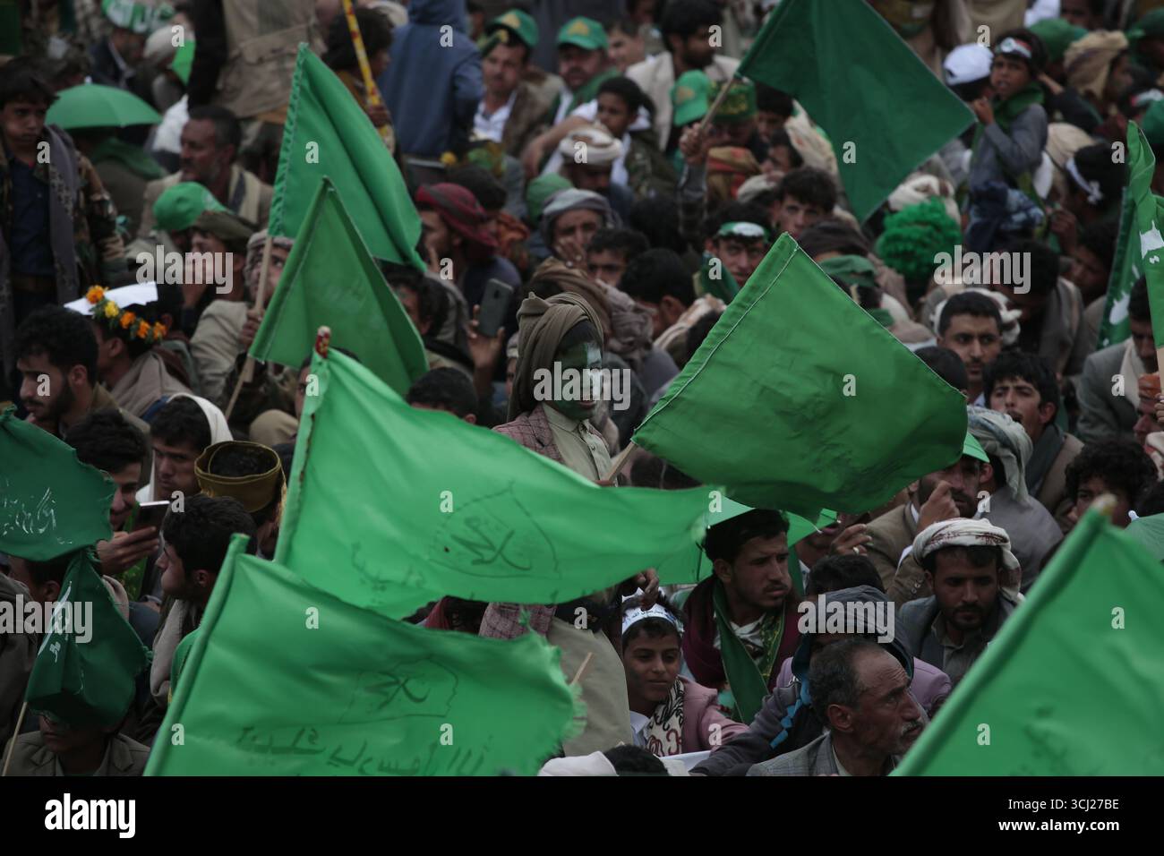 People wave Islamic flags during the Mawlid celebration marking the ...