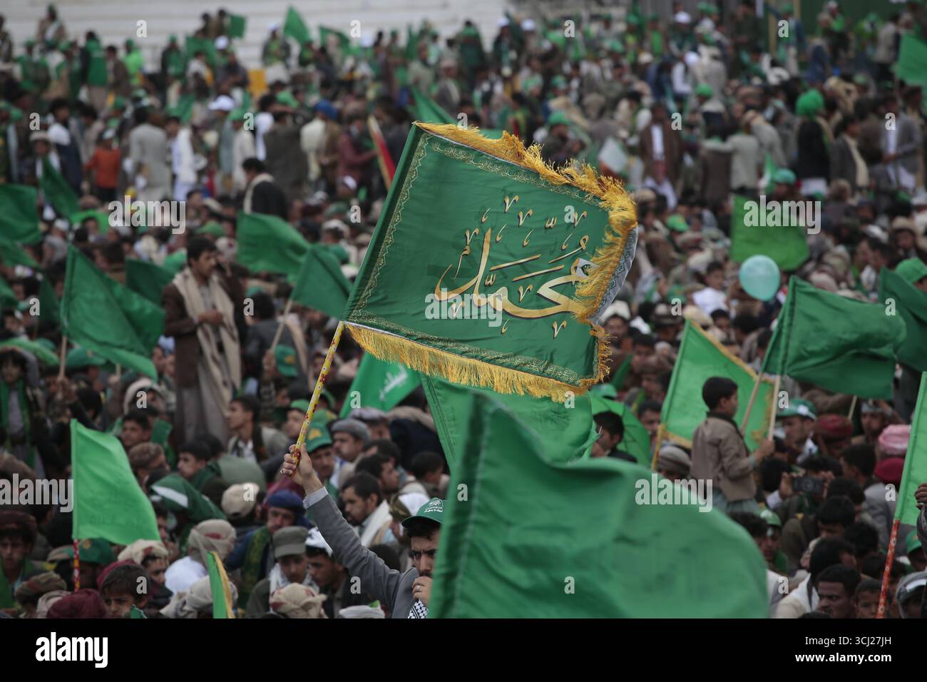People wave Islamic flags during the Mawlid celebration marking the ...