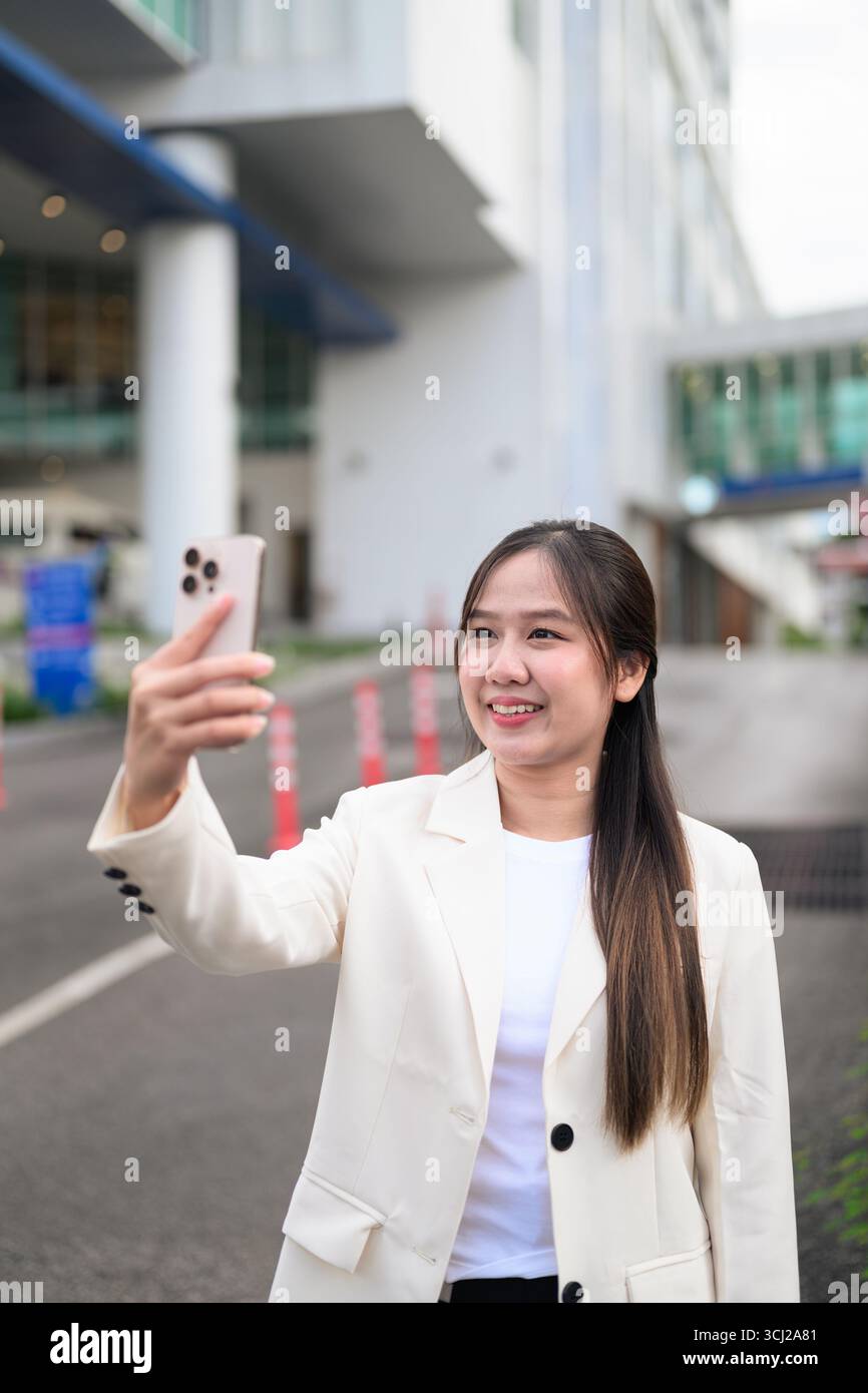 Portrait of Southeast Asian businesswoman outdoors in the city street ...