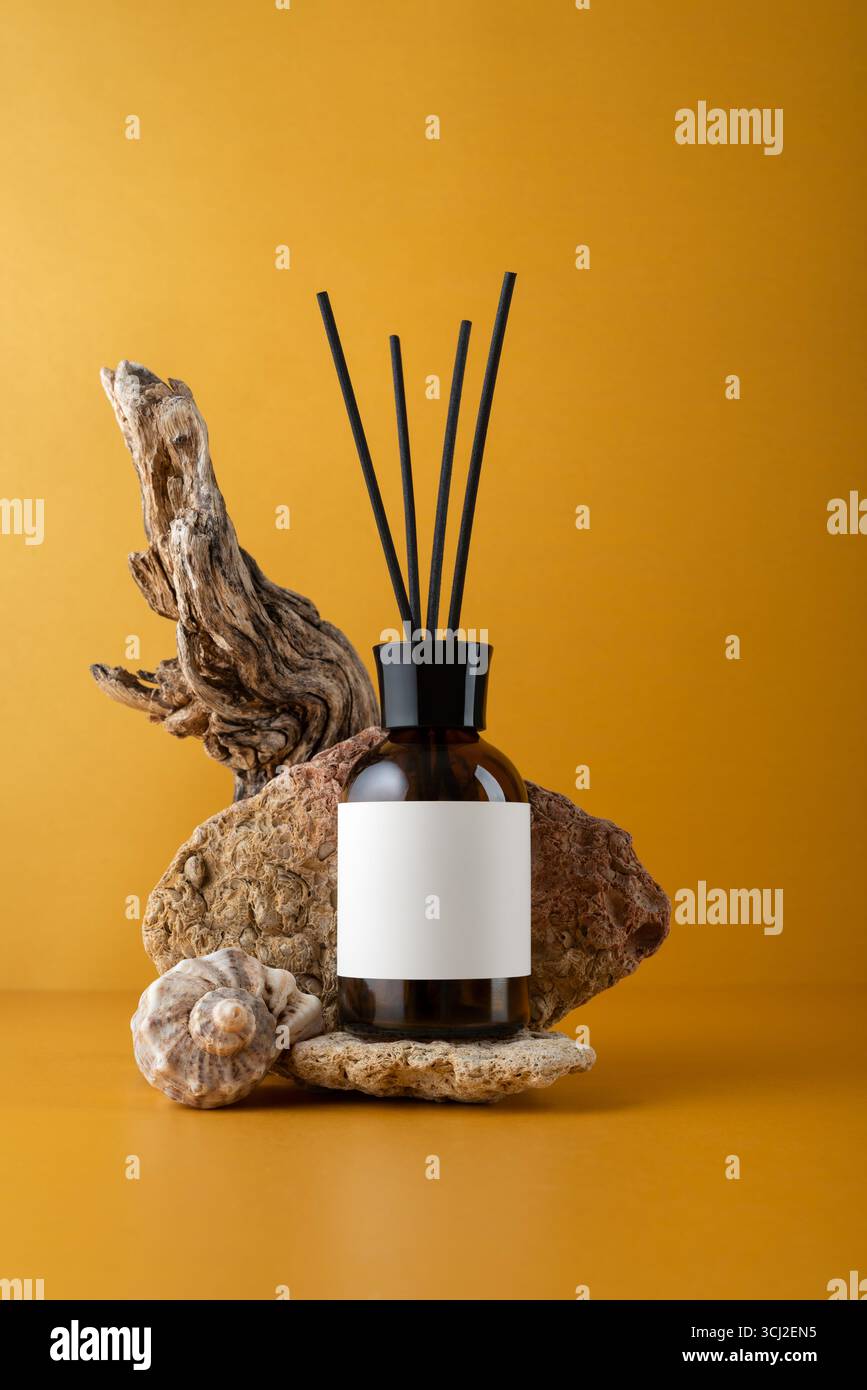 Mockup of amber glass diffuser bottle with blank label, driftwood and ...