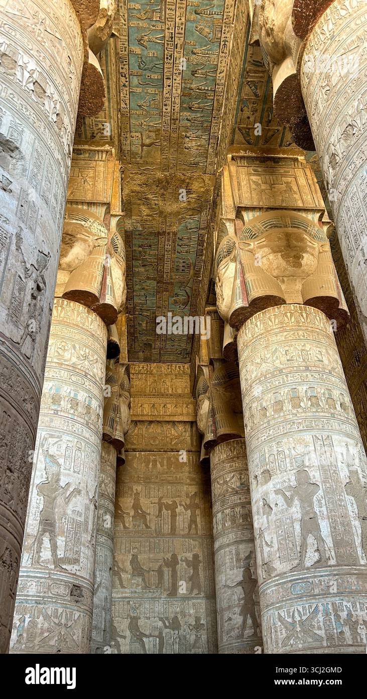 Ancient hieroglyphs and carved columns with painted ceiling details ...