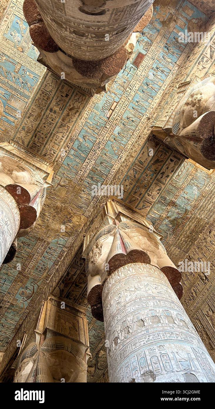 Ancient hieroglyphs and carved columns with painted ceiling details ...