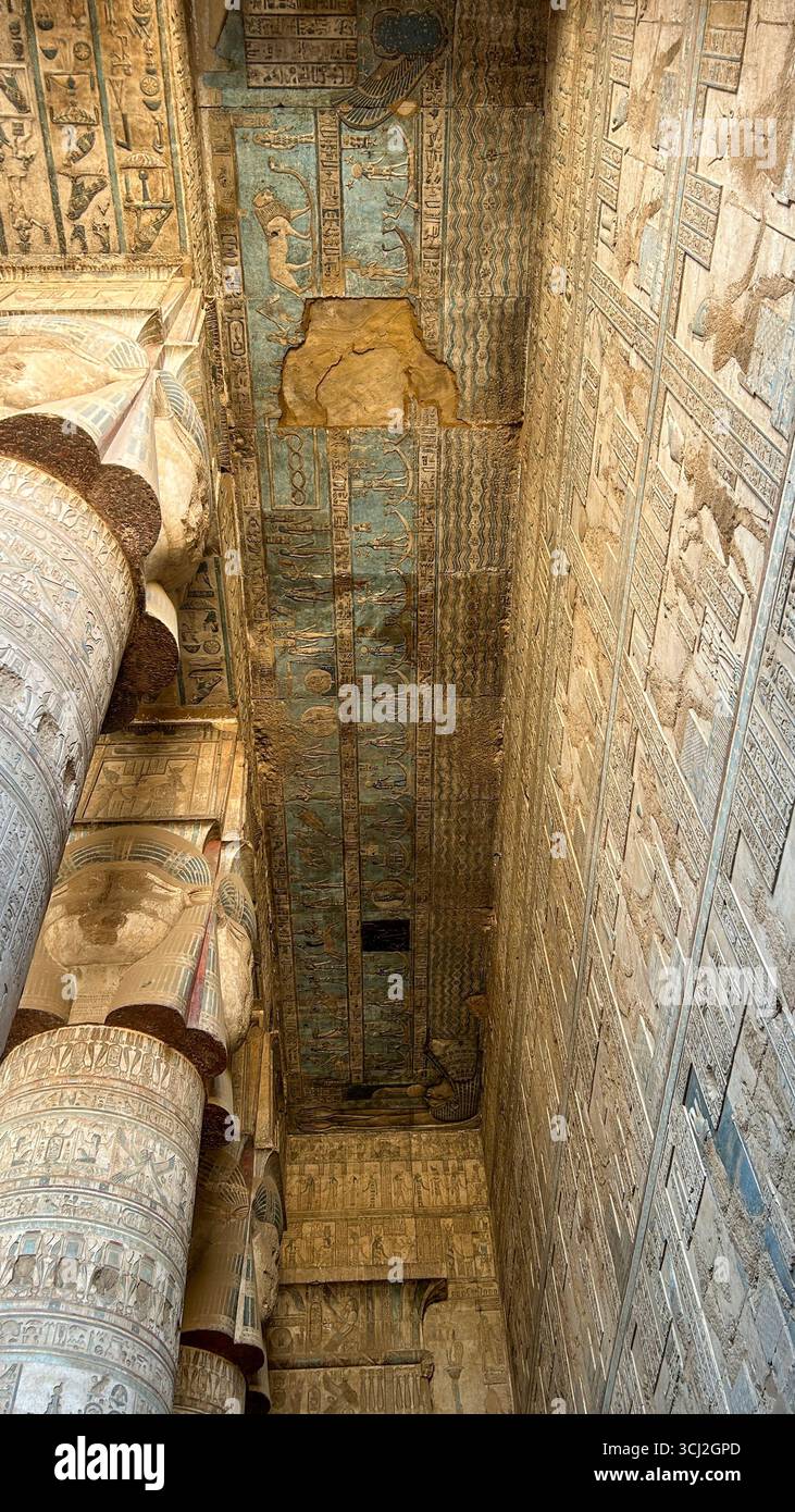 Ancient hieroglyphs and carved columns with painted ceiling details ...