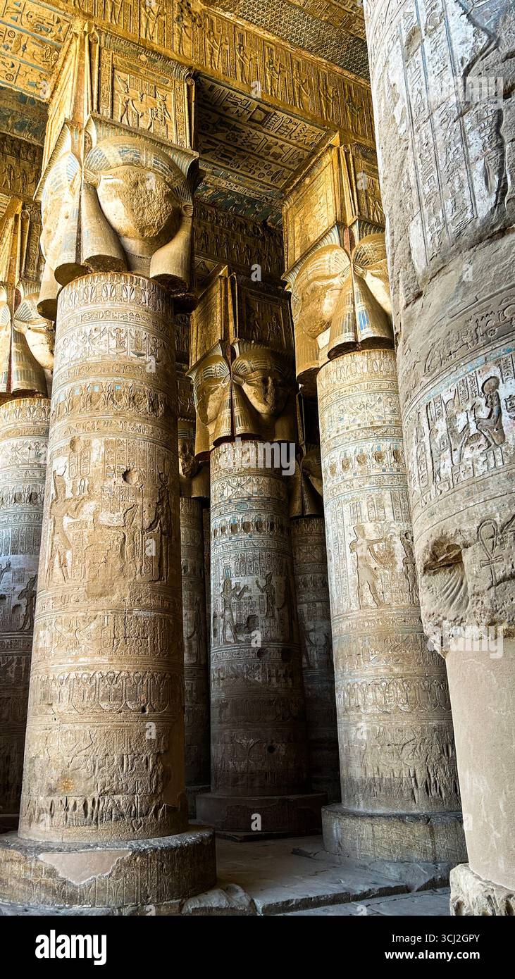 Ancient hieroglyphs and carved columns with painted ceiling details ...
