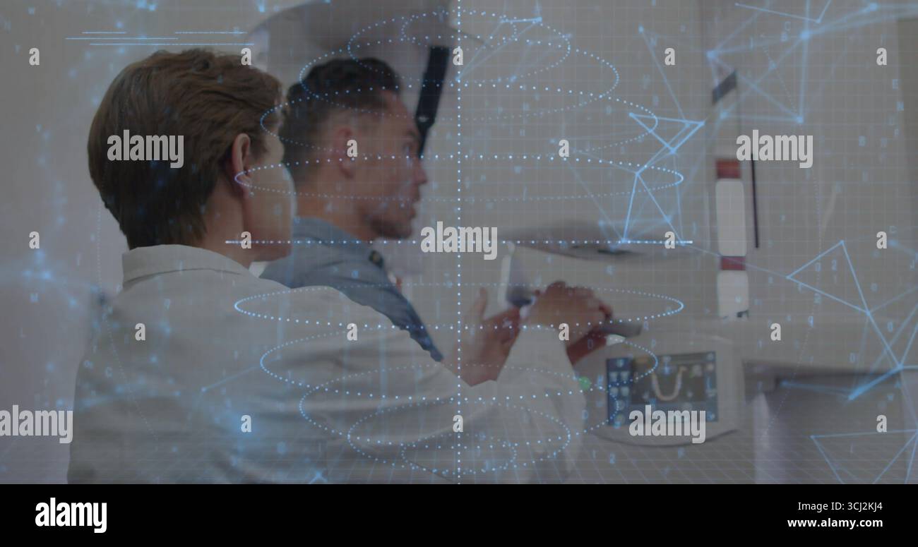 Operating lab coat techs adjusting CT scanner controls in radiology ...