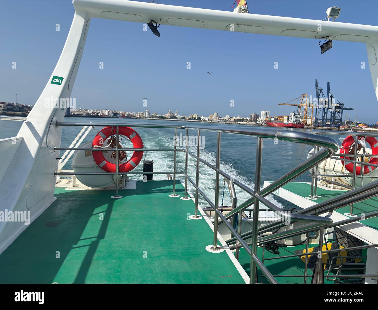 Stern view from departing boat in Cádiz Harbour, capturing receding ...