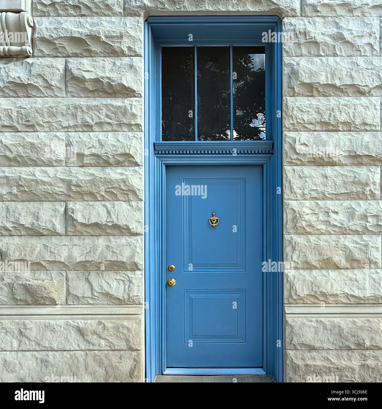 Light blue door with brass knocker and transom windows set in a ...