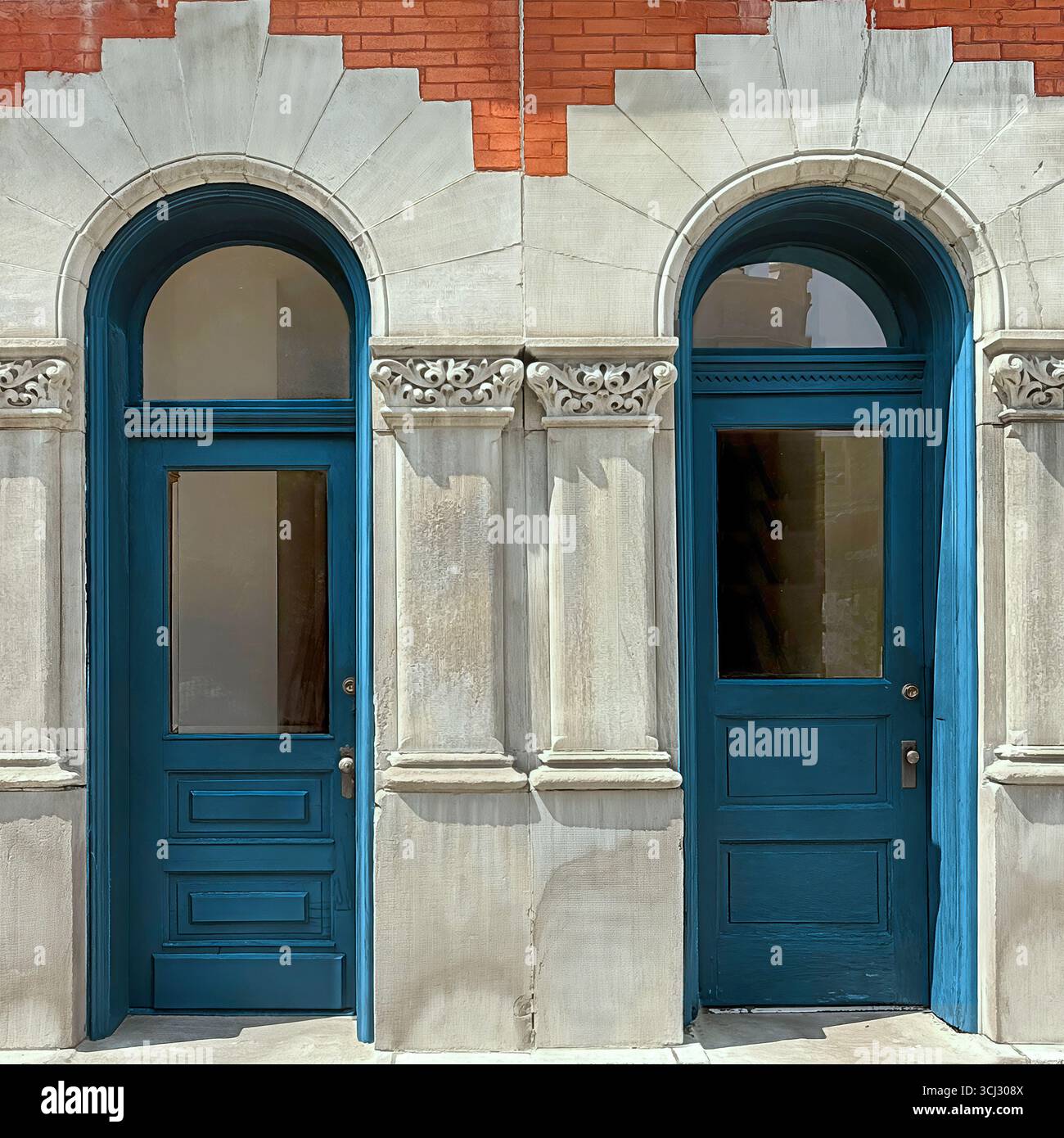 Twin arched blue doors with stone columns and ornate trim set in a ...