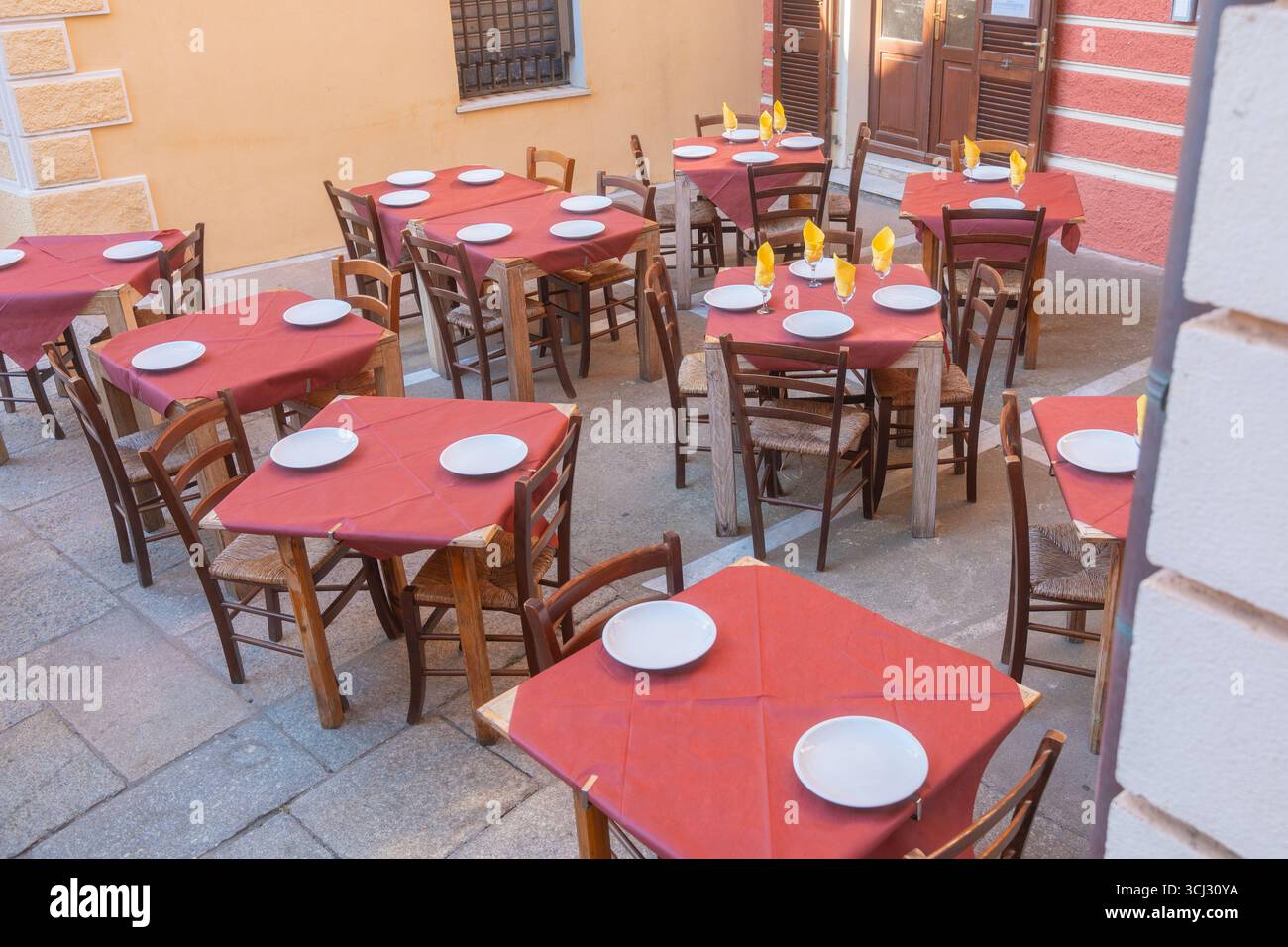Traditional Italian cafe with tables prepared for dinner, rustic chairs ...
